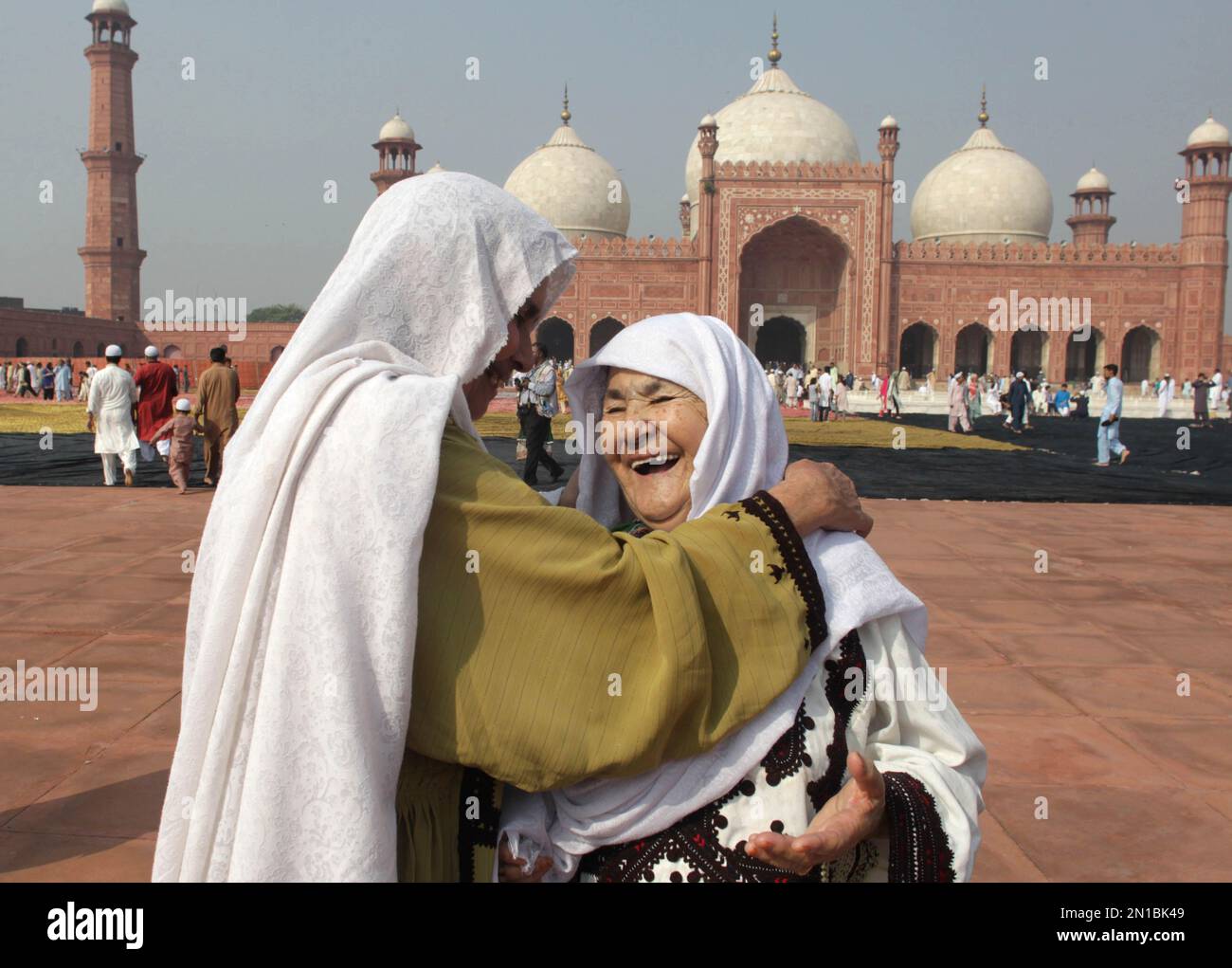 Pakistani Muslims greet each other after the Eid al-Adha prayers in ...