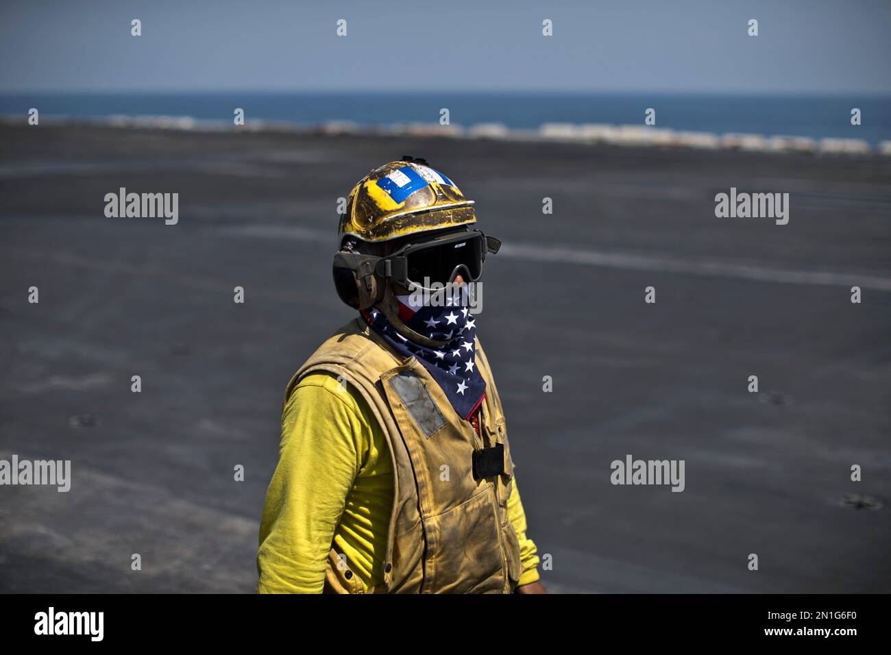 A US Navy sailor, on duty as an aircraft handling officer, wears a ...