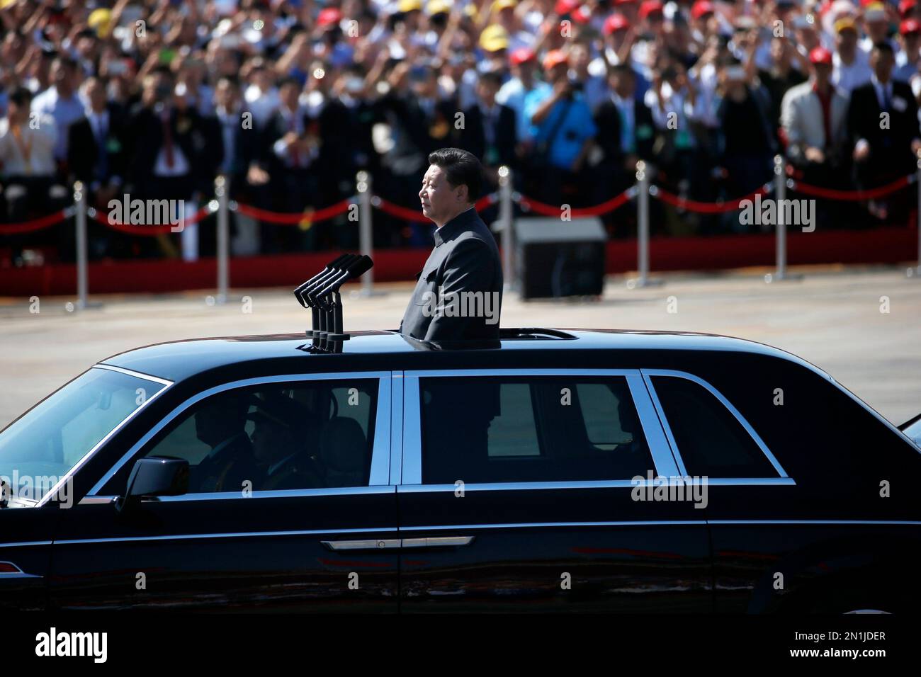 Chinese President Xi Jinping stands in a car to review the army during ...