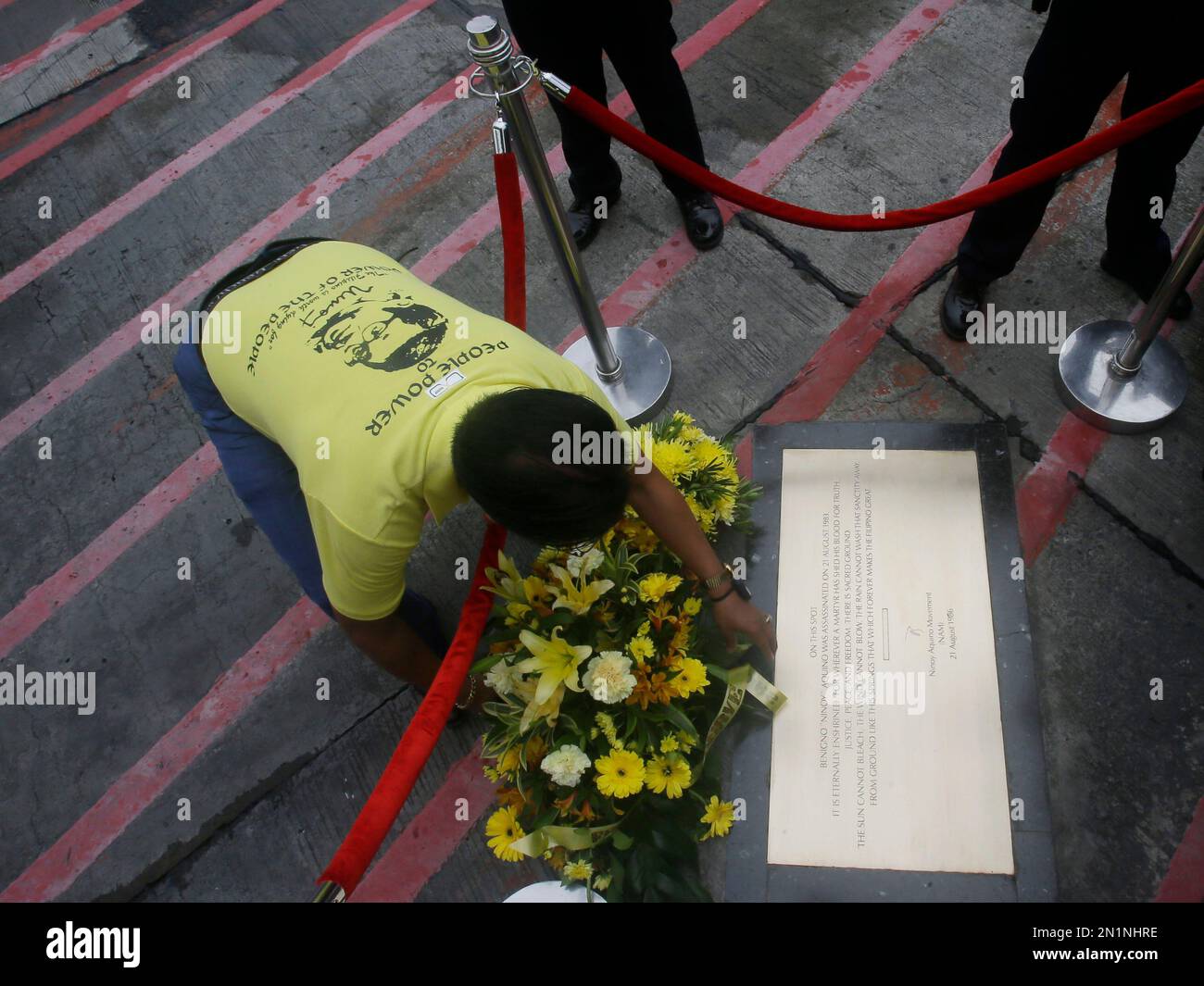 A supporter places a bouquet of flowers at the marker, the exact site ...
