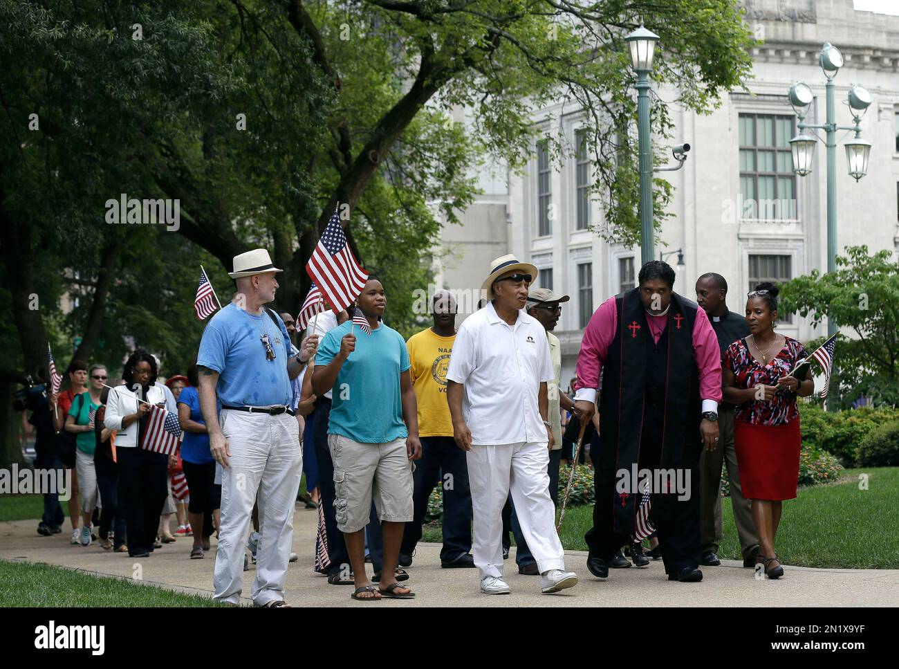 Participants march outside the State Capitol during an NAACP led ...