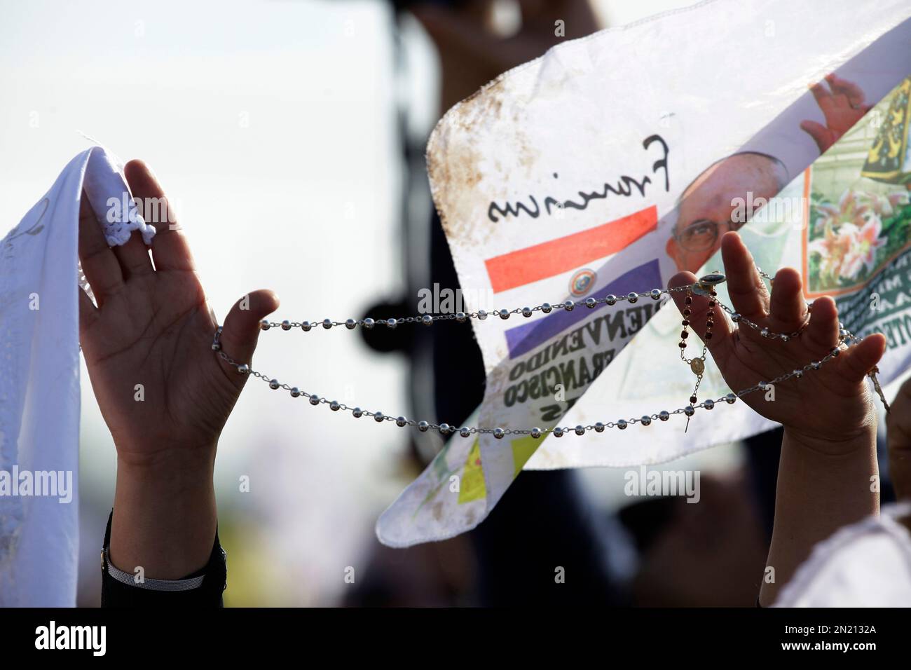 A woman holds a rosary as she waits for the arrival of Pope Francis in ...