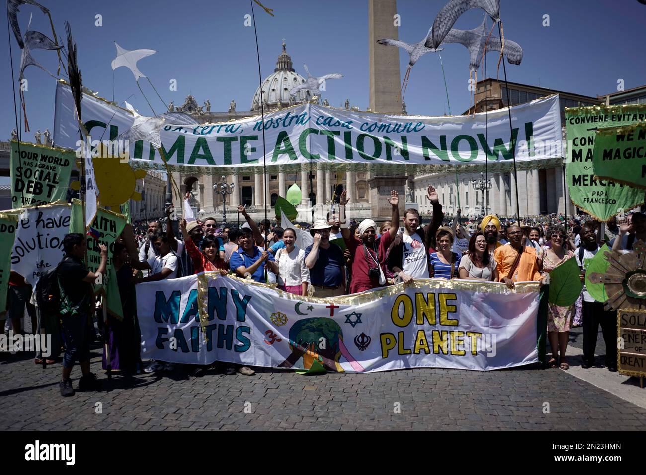 People hold banners reading ' Climate action Now ' and ' Many Faiths ...