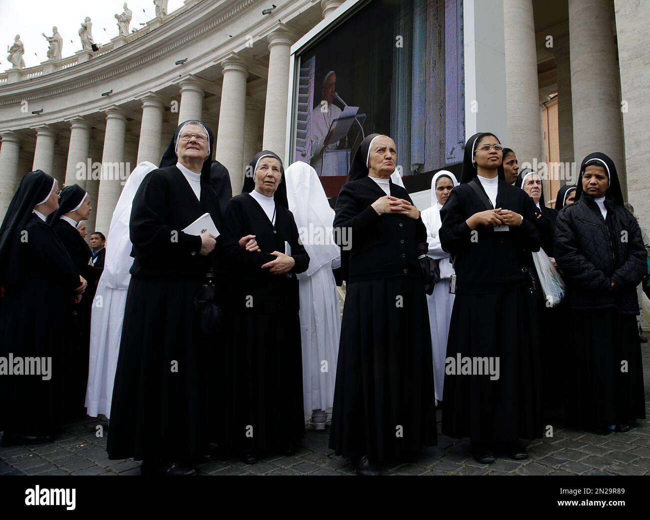 Nuns stand in St. Peter's Square as Pope Francis delivers his message ...