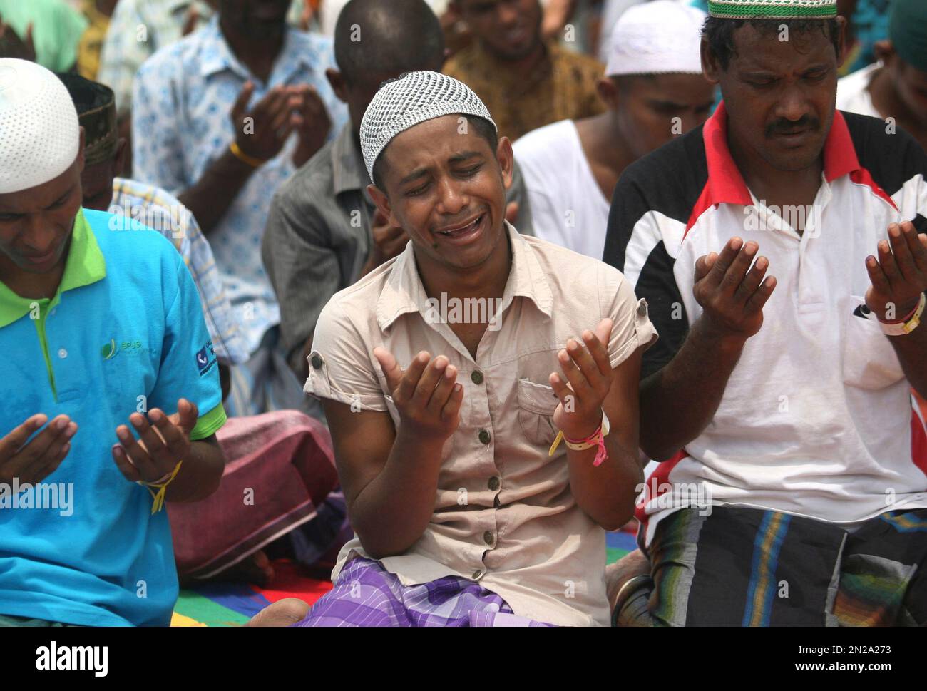 A migrant weeps during a Friday prayer at a temporary shelter in Langsa ...