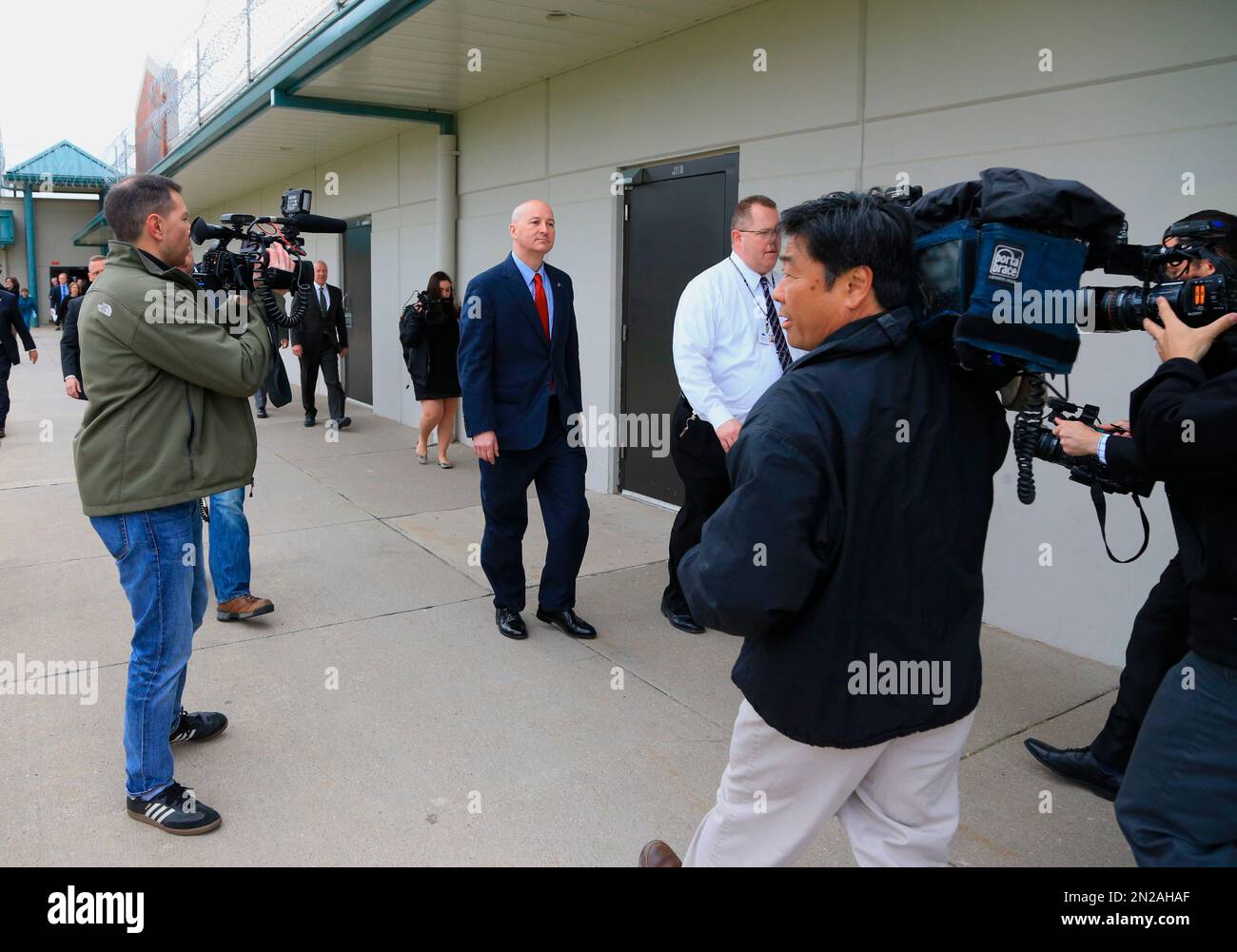 Nebraska Gov. Pete Ricketts, center, is surrounded by journalists ...