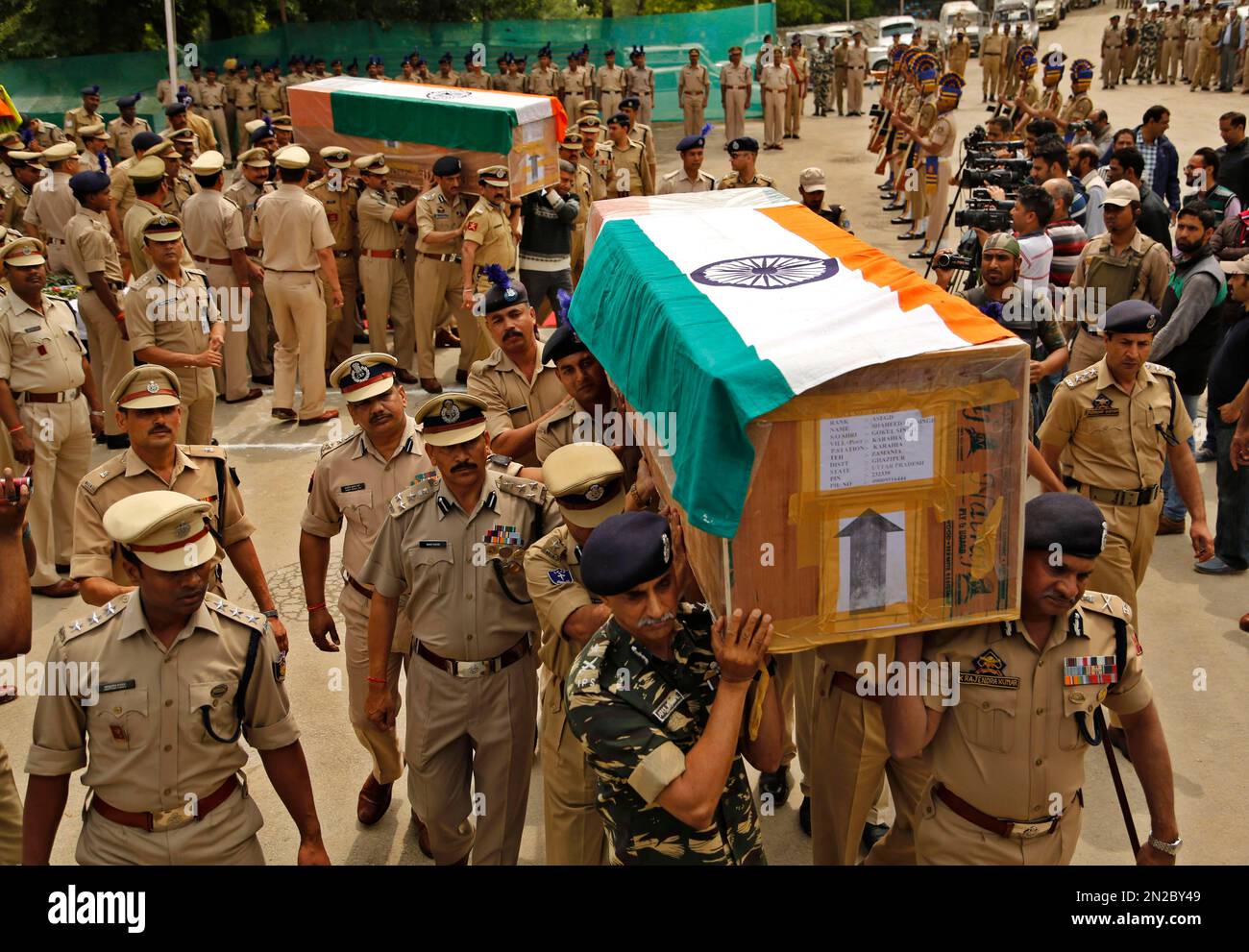 Indian police and paramilitary officers carry the coffins of slain ...