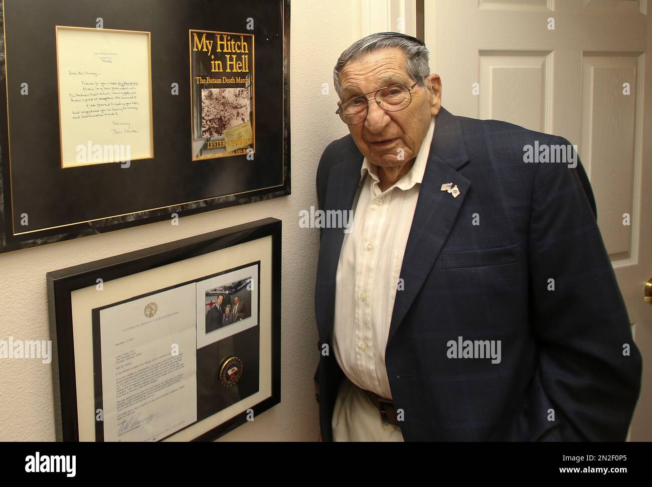 Lester Tenney poses next to a memorabilia display in his home in ...