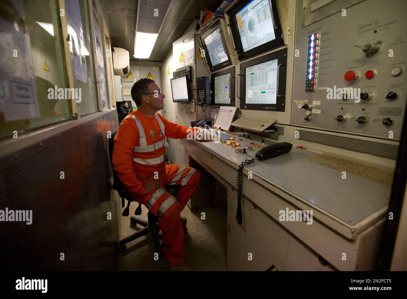 An operator sits in the driver's cab of a tunnel boring machine in the ...