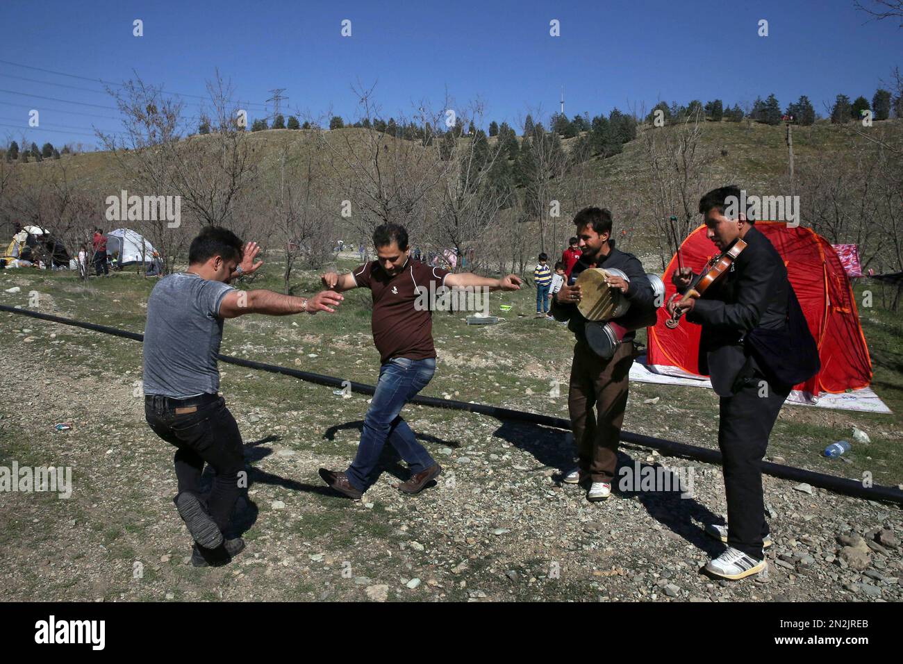 Two Iranian men dance as two street musicians play music during the ...