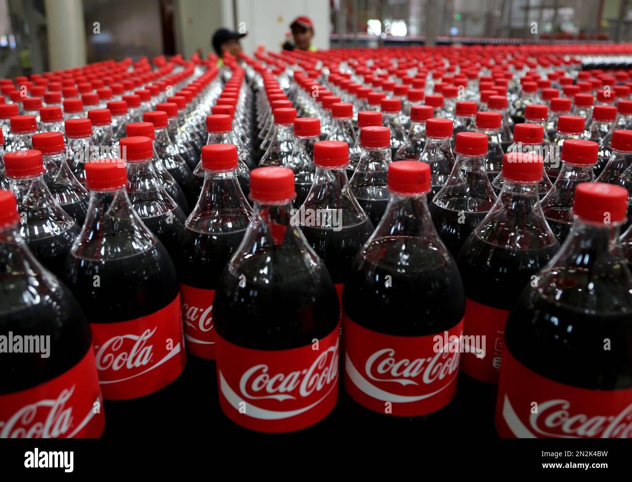 Indonesian workers inspect a new production line at a bottling plant ...