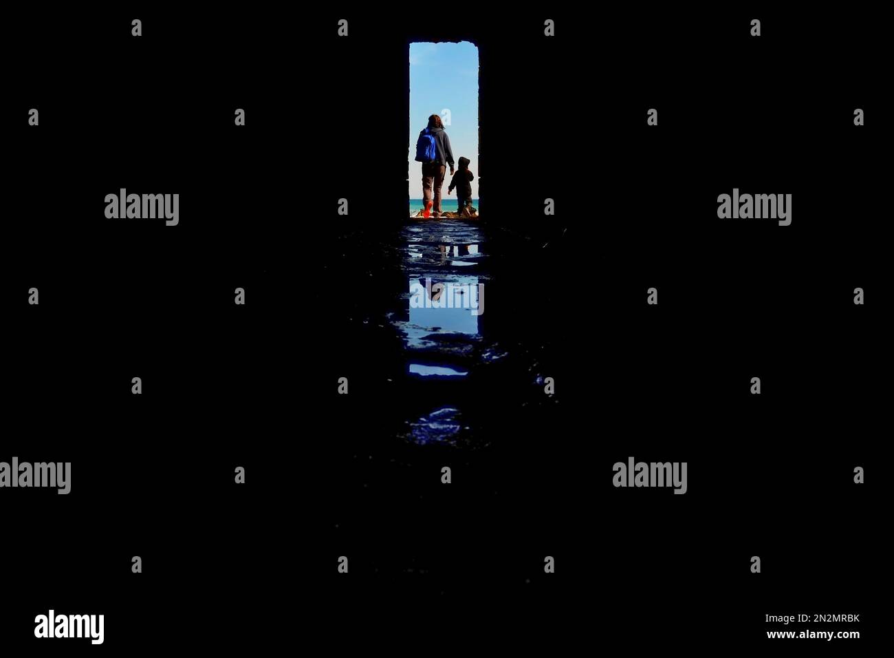 A mother and her child traverse an underground walkway leading to ...