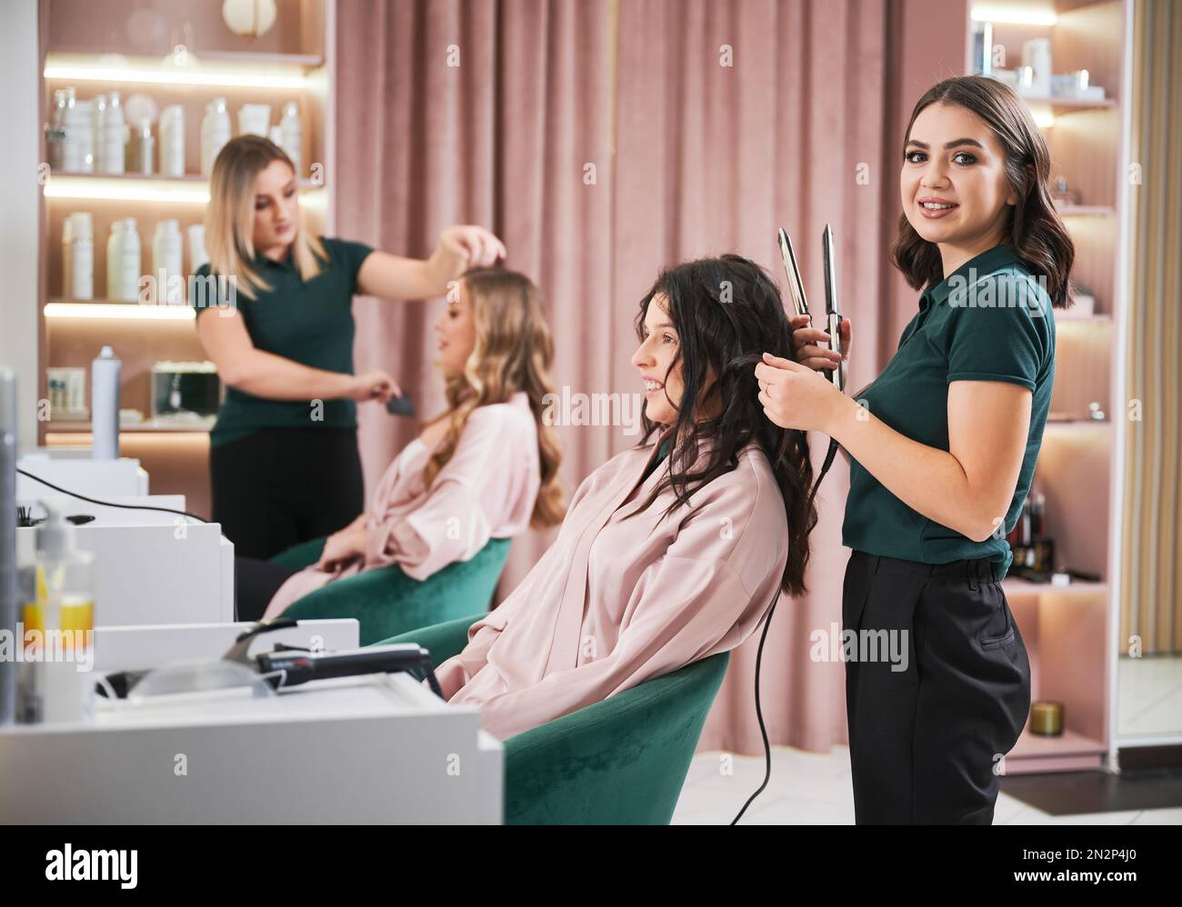 Portirait eines professionellen Friseurs, der Frisuren für eine Frau im ...