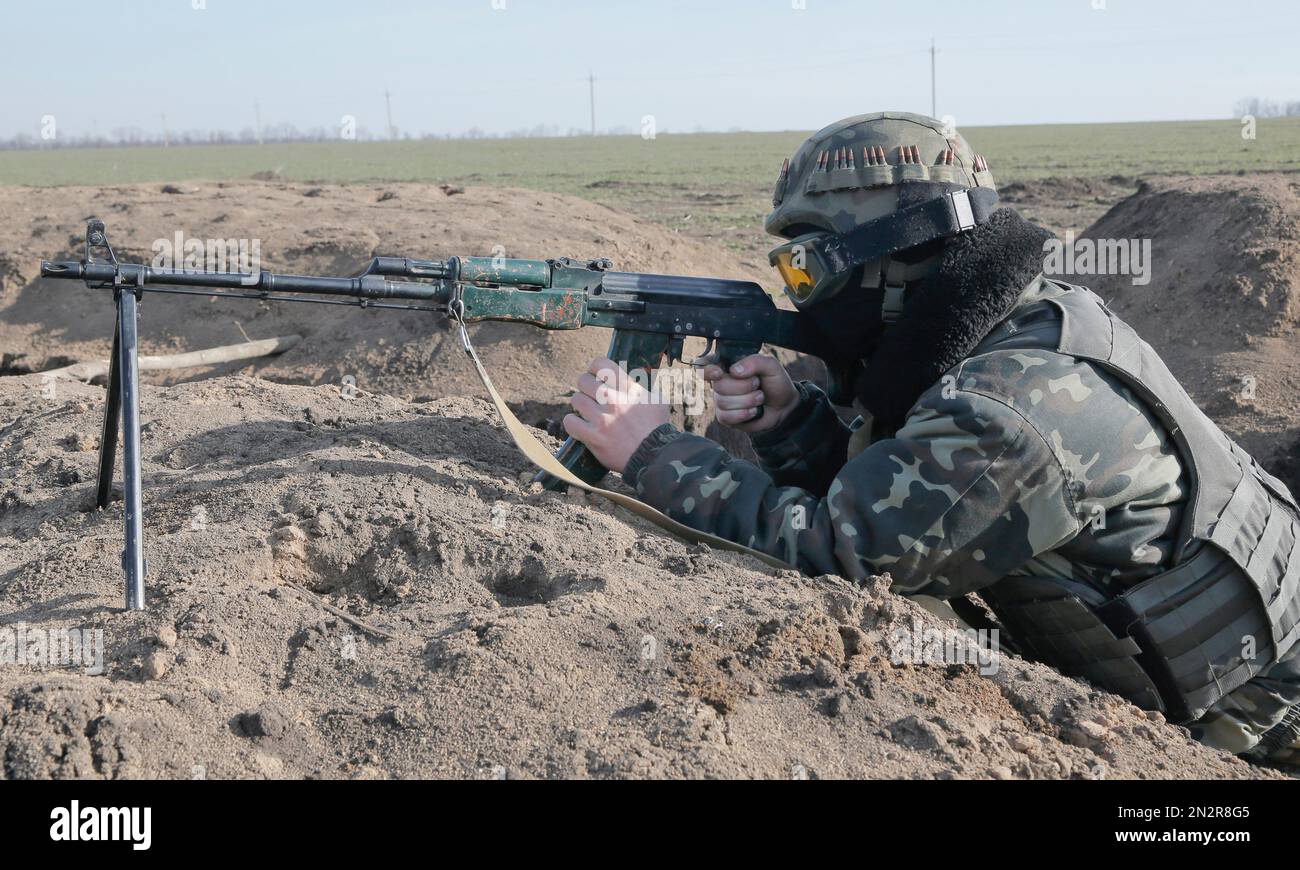 A Ukrainian serviceman takes position at the front line outside ...