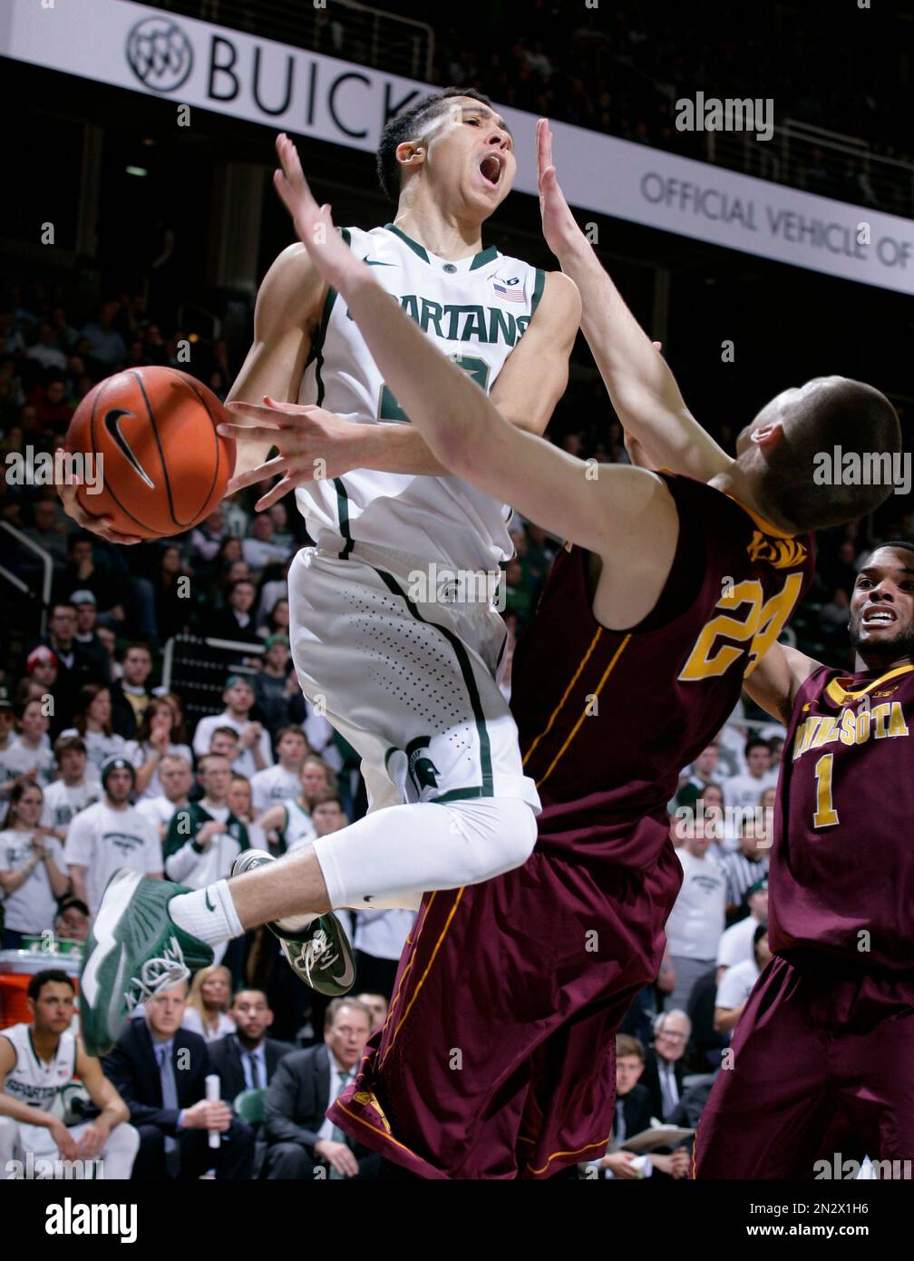 Michigan State's Travis Trice, left, drives and drawls a foul by ...