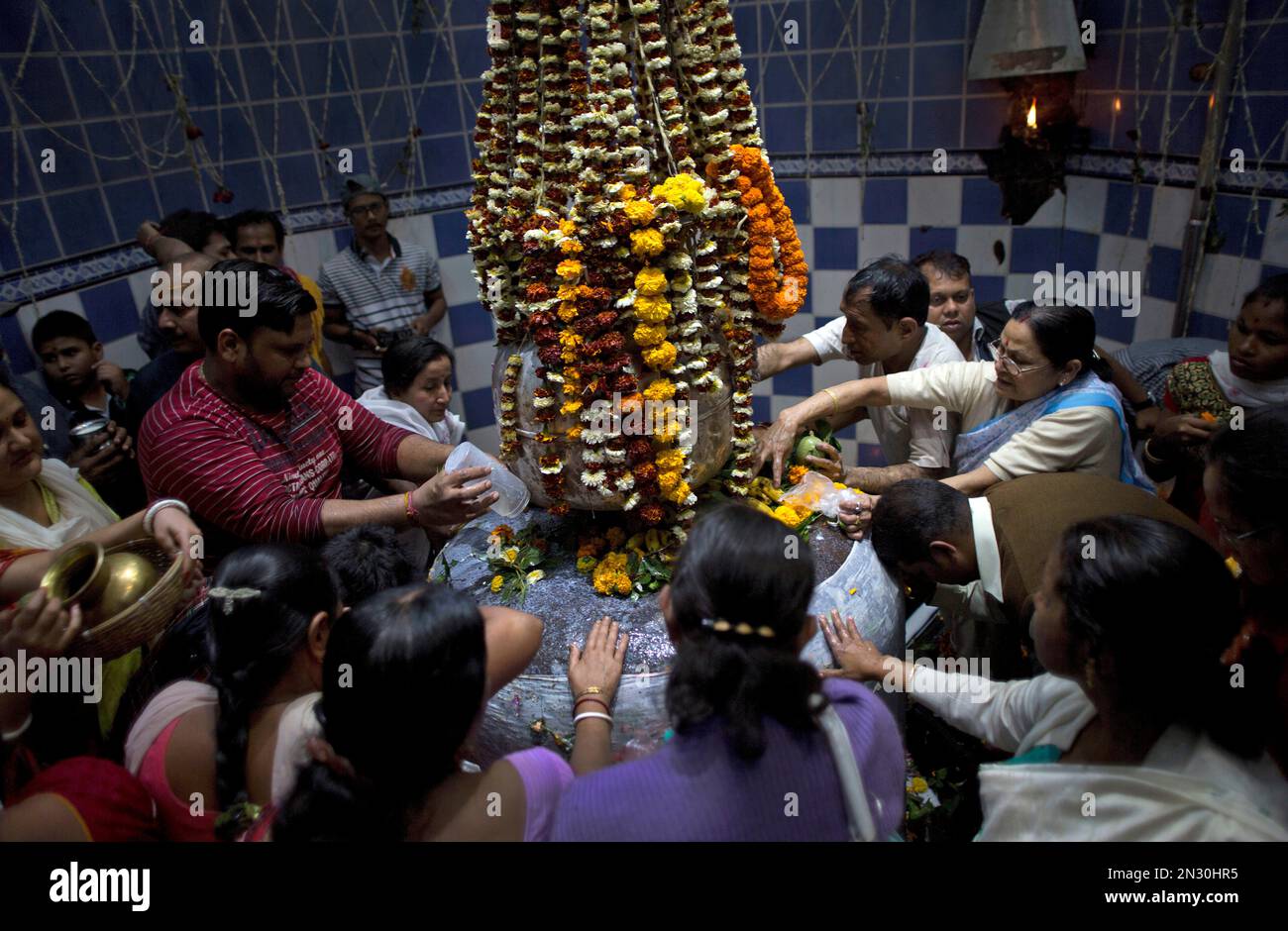 Devotees give offerings to a Shivling, a symbolic representation of ...