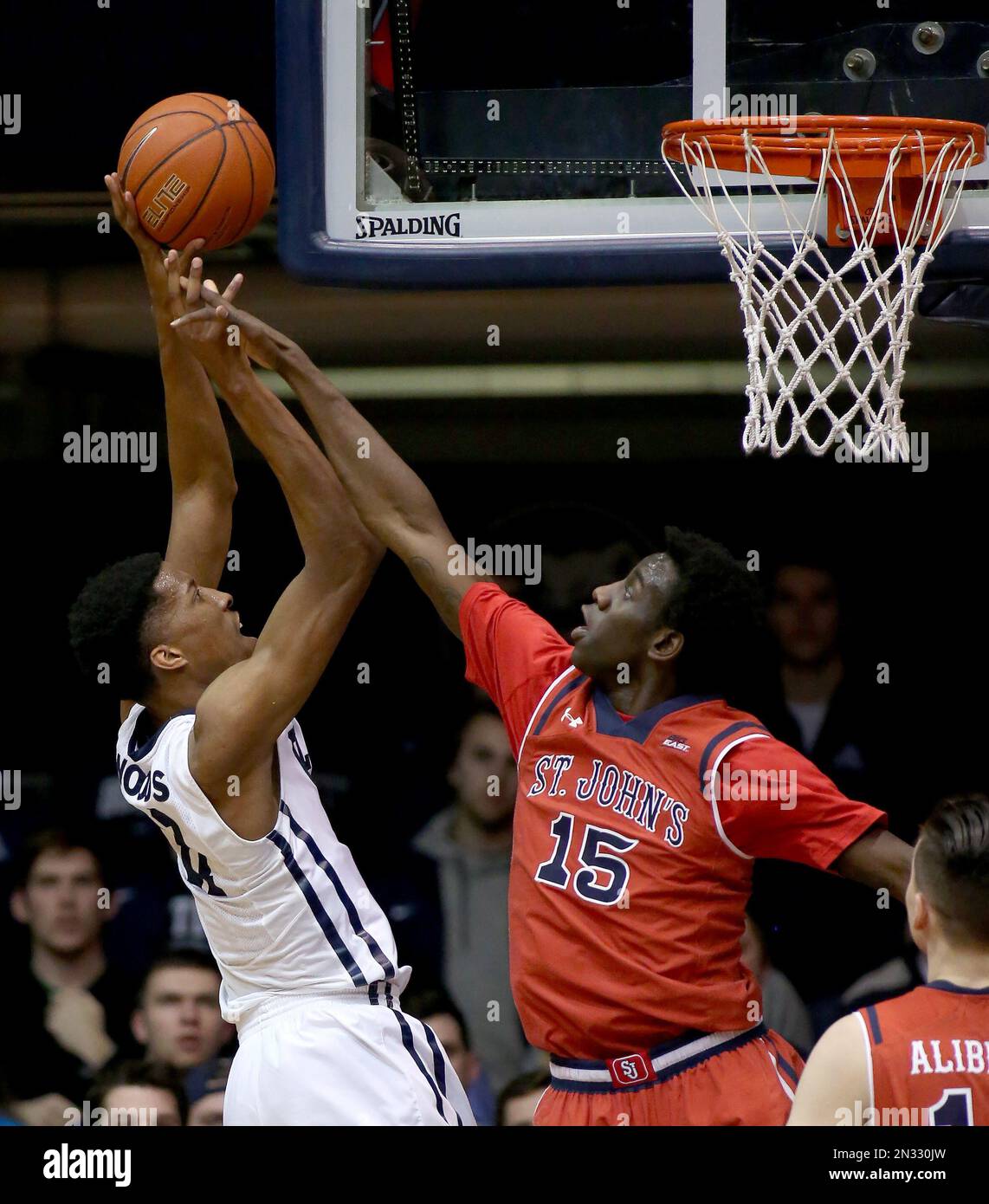 Butler forward Kameron Woods, left, goes up for a shot against St. John ...