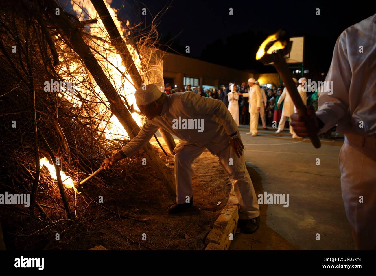 An Iranian Zoroastrian priest sets fire to a prepared pile of wood in a ...