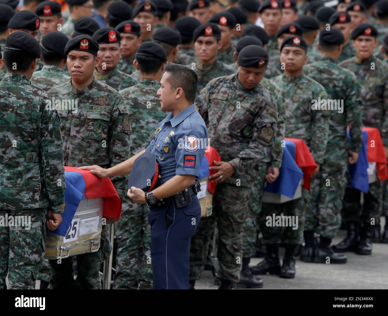 A police officer touches the flag-draped casket of a fallen member of ...