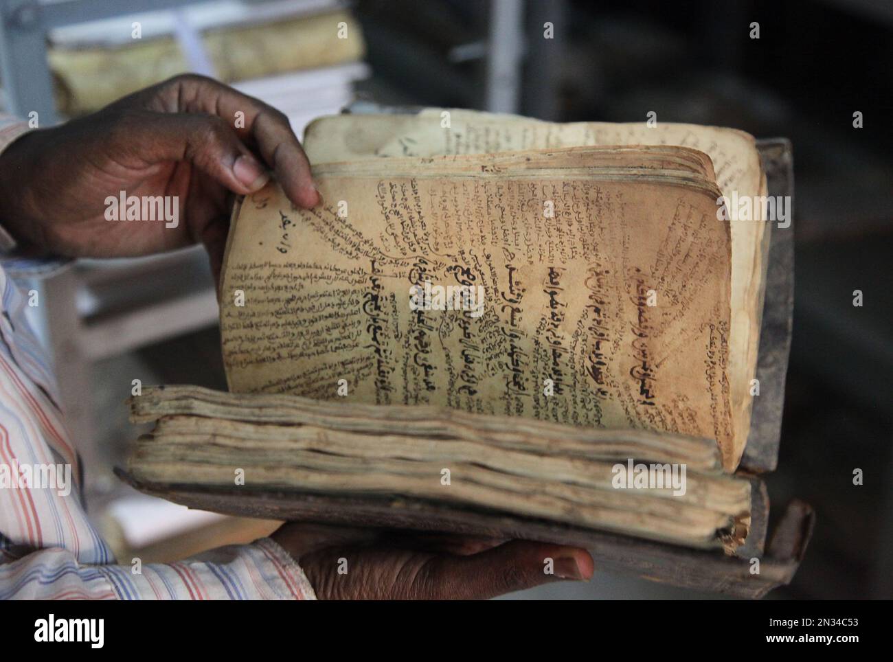 A man holds an ancient manuscript that will need to be restored after ...