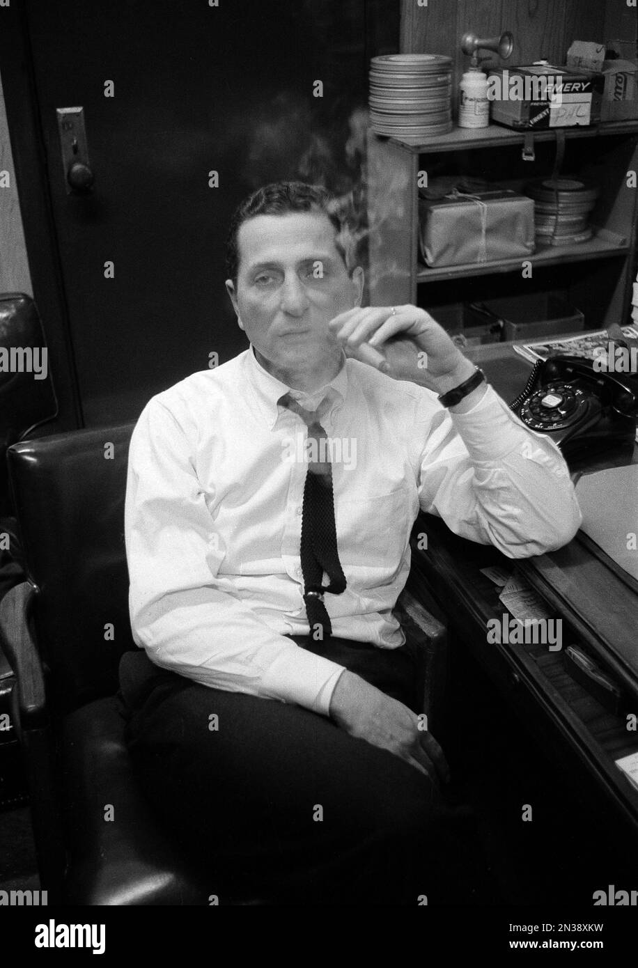 Allie Sherman, coach of the New York Giants, smokes in his office after his dream of the NFL ...