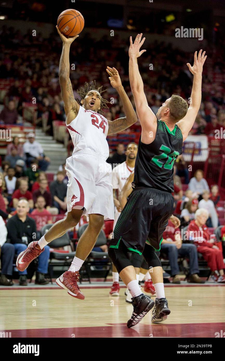 Arkansas guard Michael Qualls, left, pulls back for a jump shot as Utah ...