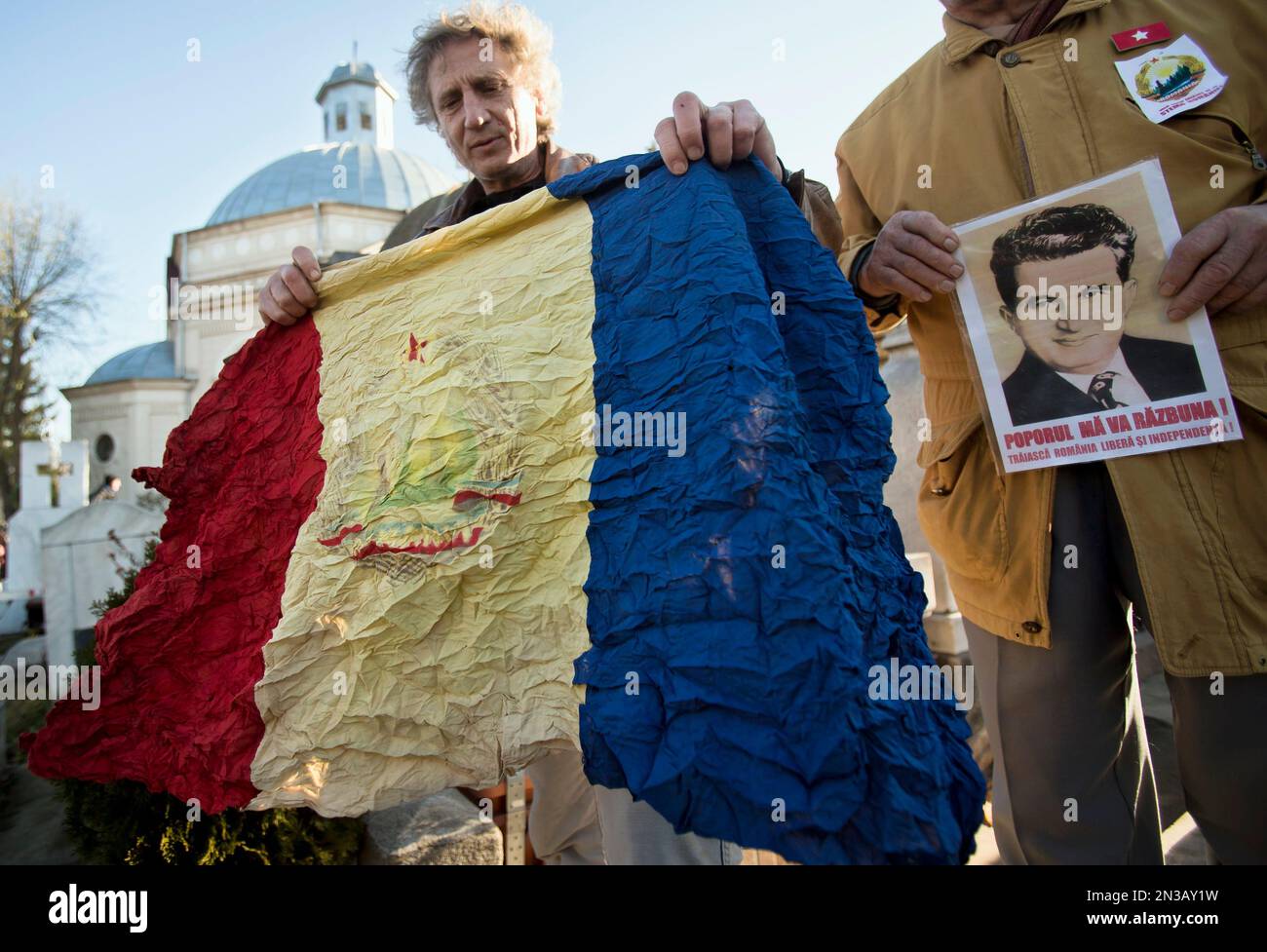Men hold a picture of Romanian communist dictator Nicolae Ceausescu and ...