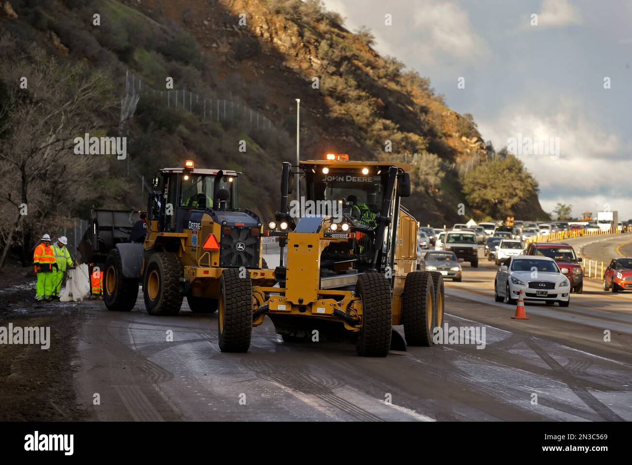Caltrans crews work to clean up a torrent of mud and rocks covering ...