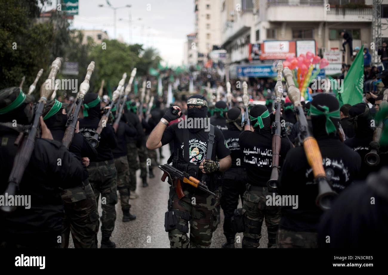Palestinian Hamas masked gunmen march in a rally to commemorate the ...