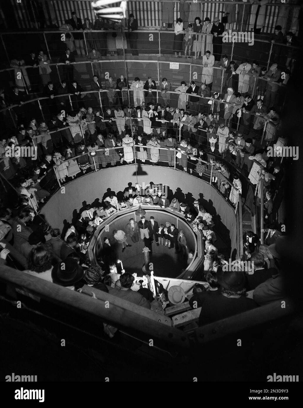 Spectators watch thrill-seekers spin in a giant drum-like amusement ...