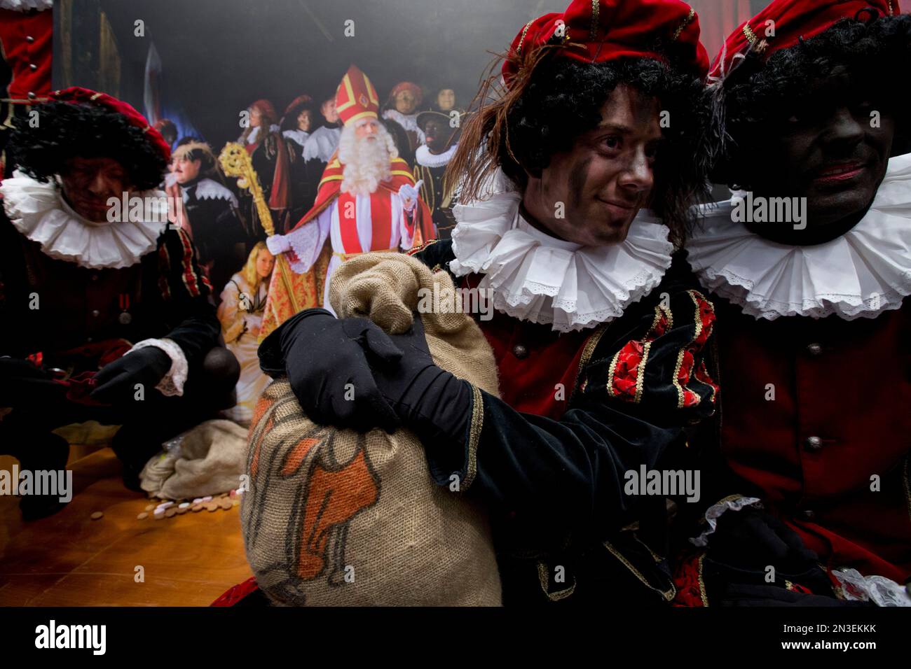 A Black Pete, right, and a Chimney Pete, second right, pose in front of ...