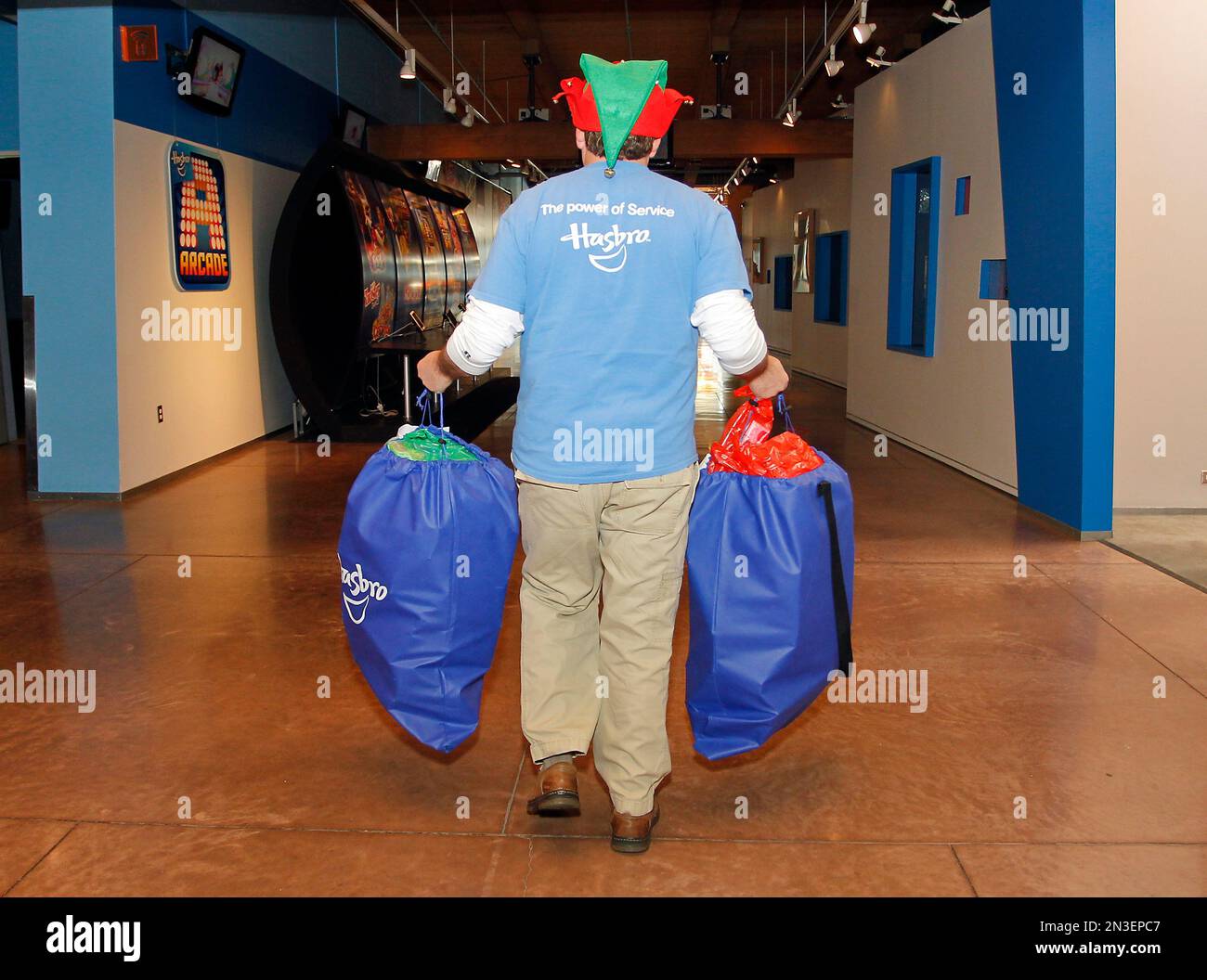 IMAGE DISTRIBUTED FOR HASBRO - A Hasbro employee carries sacks of toys ...