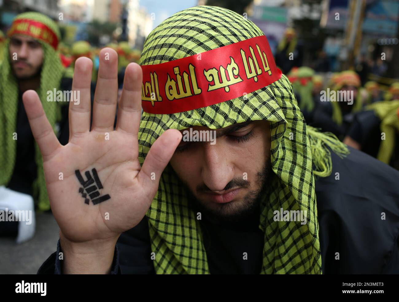 A Lebanese Shiite supporter of Hezbollah with a bandana on his head ...