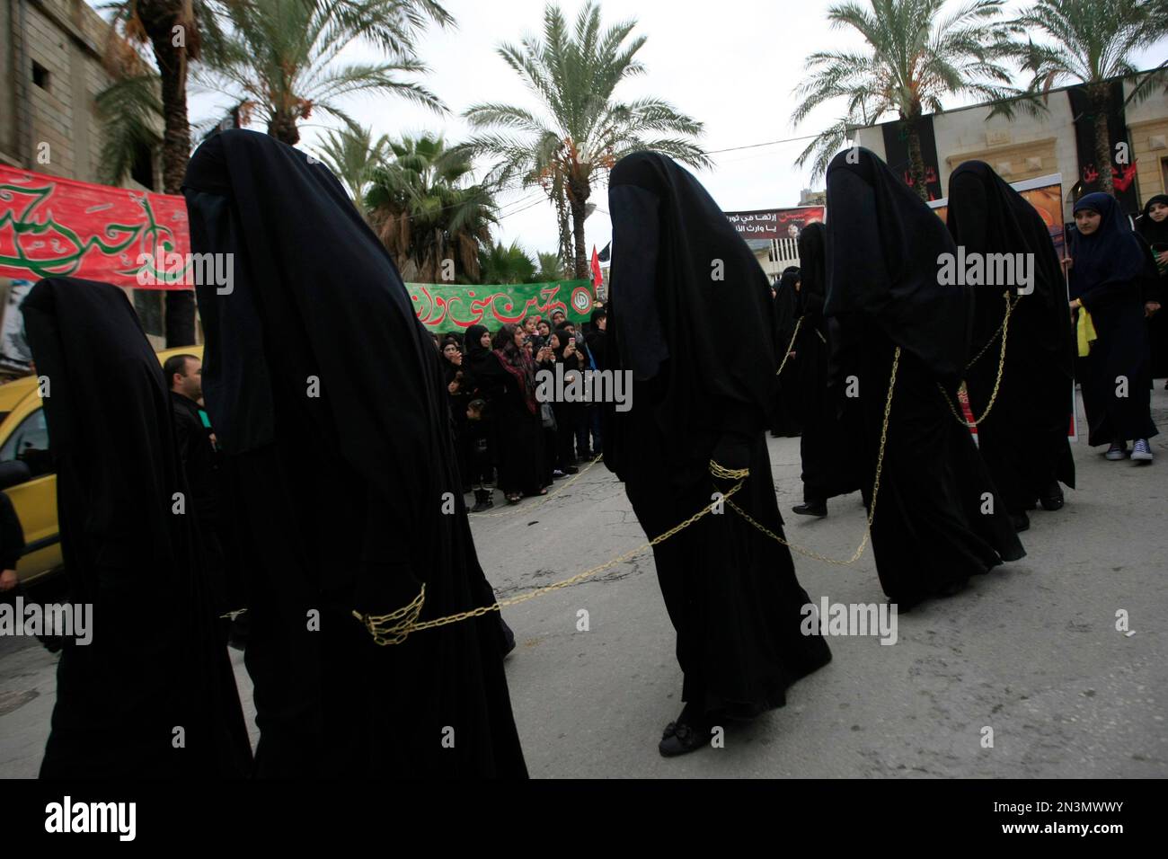 Lebanese Shiite Muslim women with their hands in chains reenact part of ...