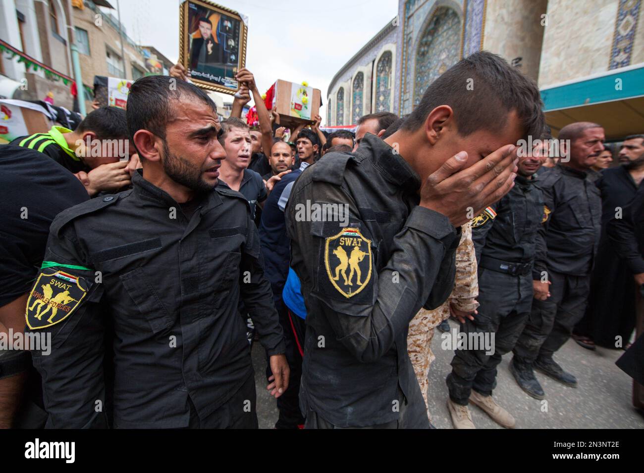 Members of Iraq's Special Weapons and Tactics Team (SWAT) mourn during ...