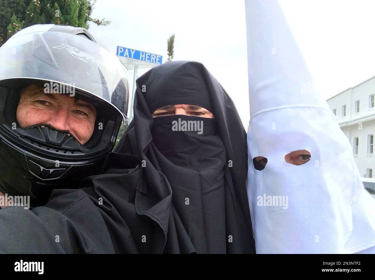 Three men wearing a Ku Klux Klan hood, a niqab and a motorcycle helmet ...