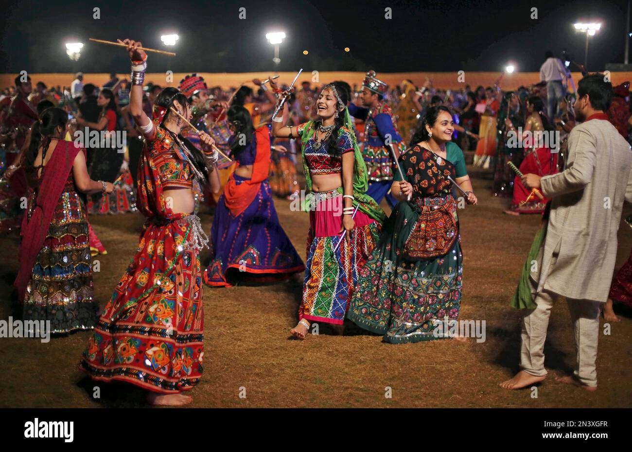 Indian men and women in traditional attire perform Garba, a traditional dance of Gujarat state ...