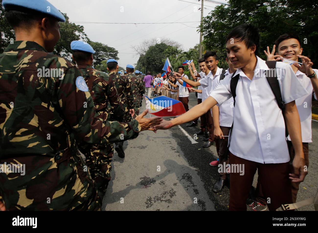 Students wave Philippine flags to cheer Filipino UN Peacekeepers as ...