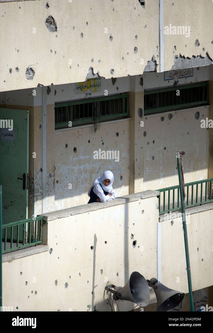 A Palestinian school girl stands outside her classroom during the first ...