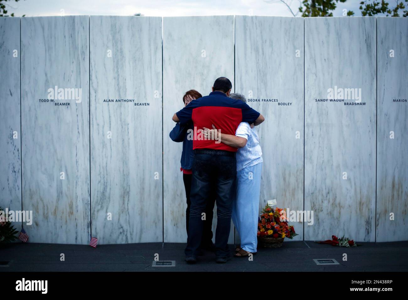 Rick Sarmiento, center, embraces Karen Bingham, left, and Nancy Root ...