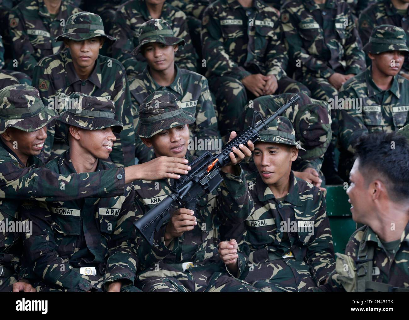Philippine Army recruits inspect a new M4 assault rifle issued to ...