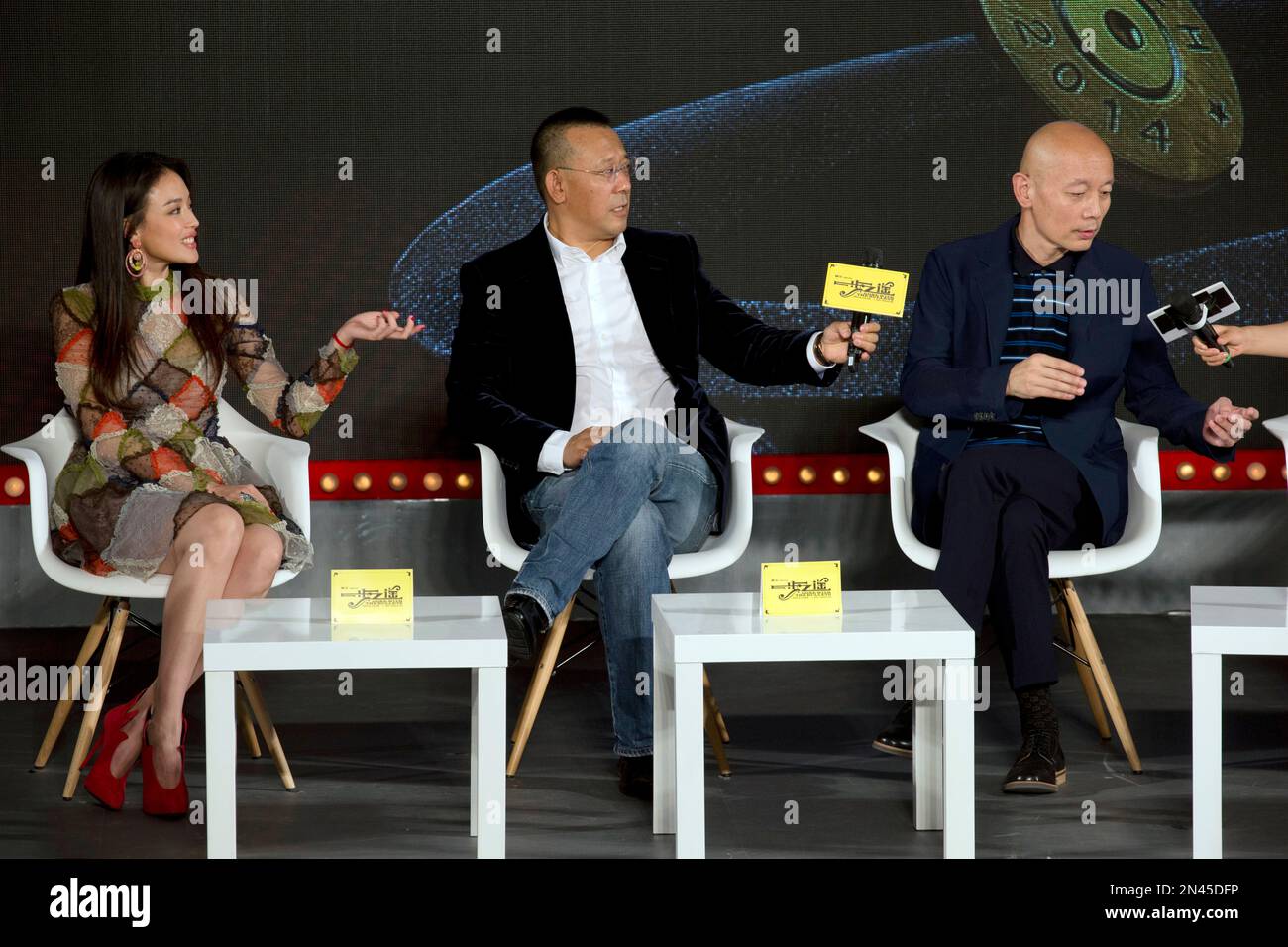 Chinese director Jiang Wen, center, offers the microphone to Chinese ...