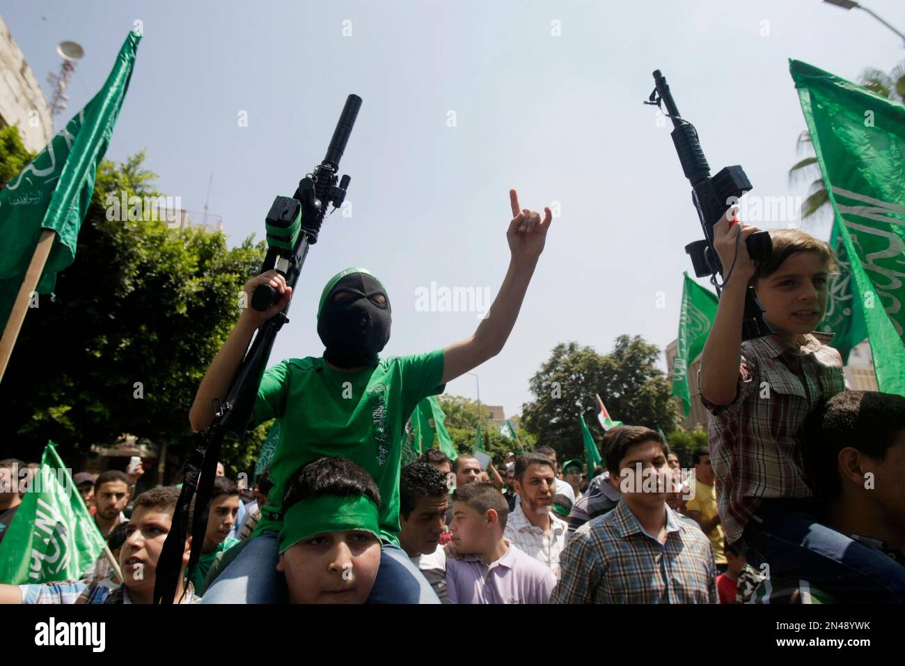 Palestinian boys with Hamas supporters hold toy guns and shout slogans ...
