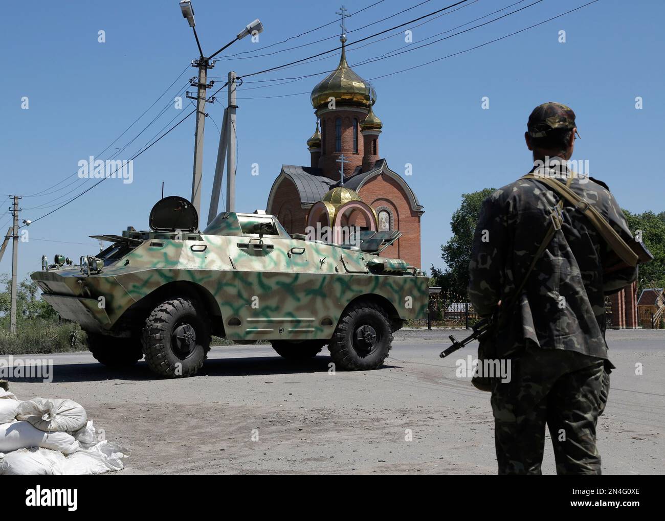 A pro-Russian fighter stands guard at a checkpoint in the village of ...