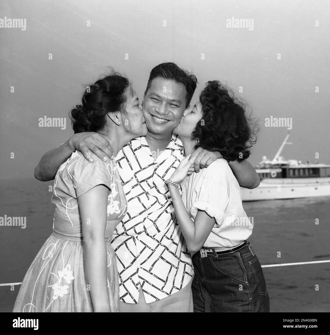 Former Secretary of Defense Ramon Magsaysay, center, receives a kiss and a hug from his wife ...