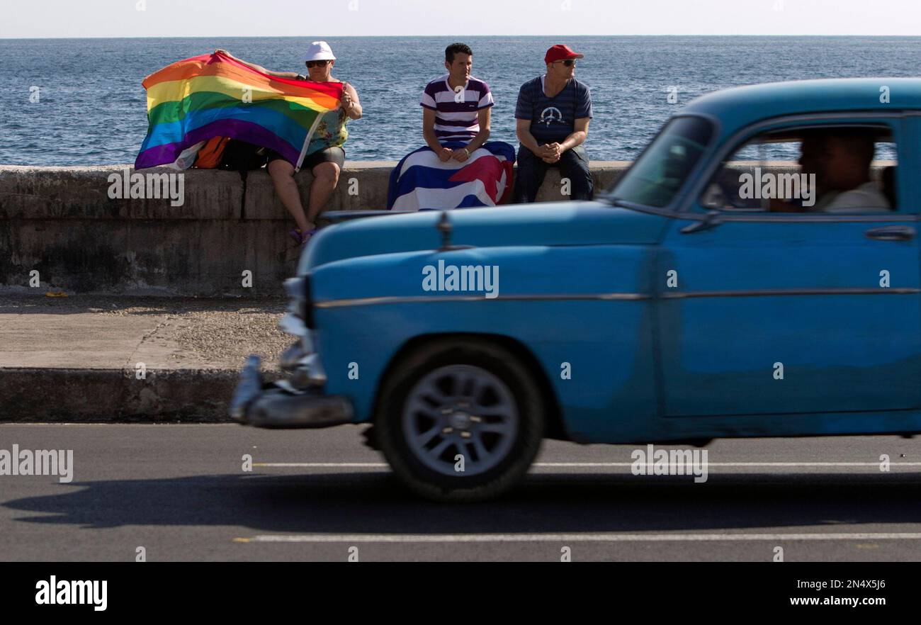 Spectators, holding a pride banner and a representation of Cuba's ...