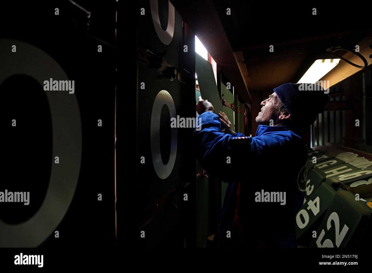 In this April 10, 2014 photo, scoreboard operator Brian Helmus changes ...