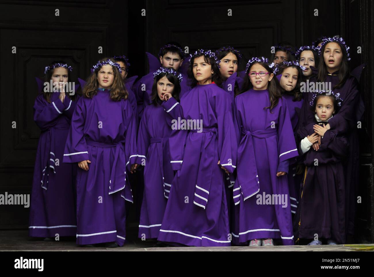 Children stand by a church entrance as they follow the re-enactment of ...