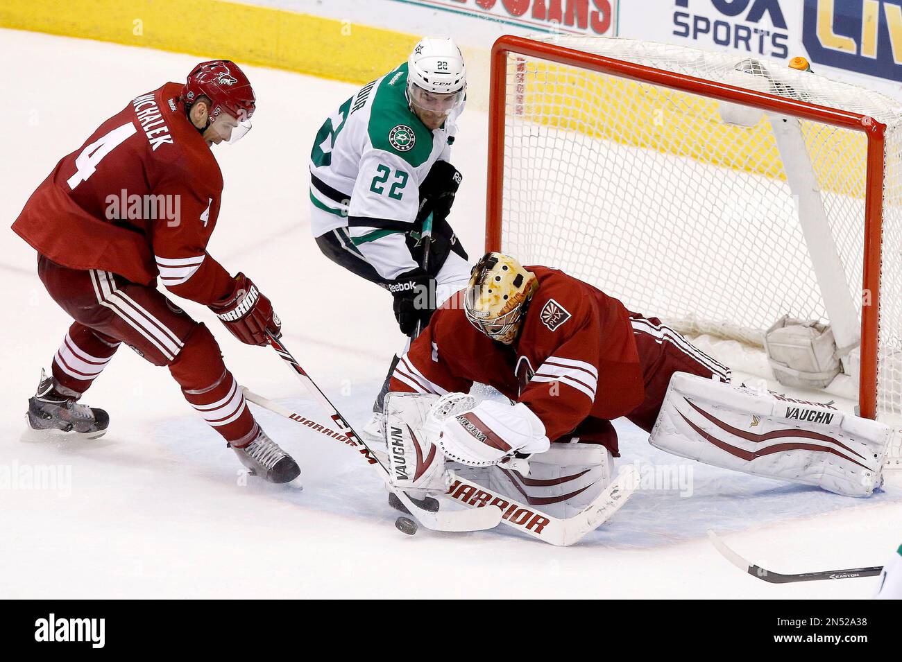 Phoenix Coyotes' Thomas Greiss, right, of Germany, dives on the puck to ...