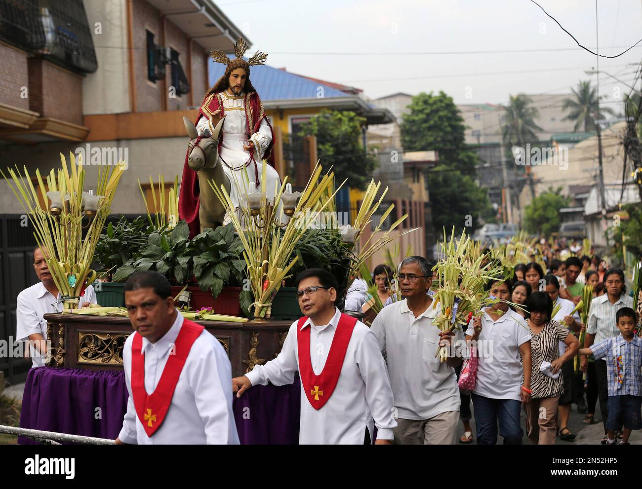 Filipino devotees pull an image of Jesus Christ riding a donkey during ...